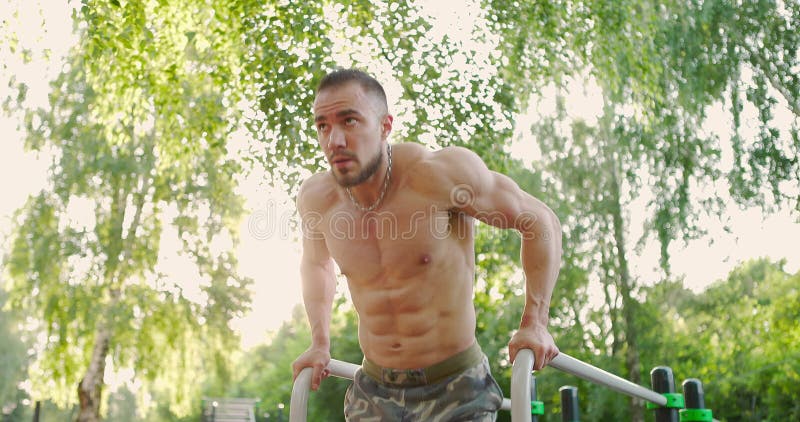 Handsome Bodybuilder Performing Exercise on Parallel Bars Alone.Man ...