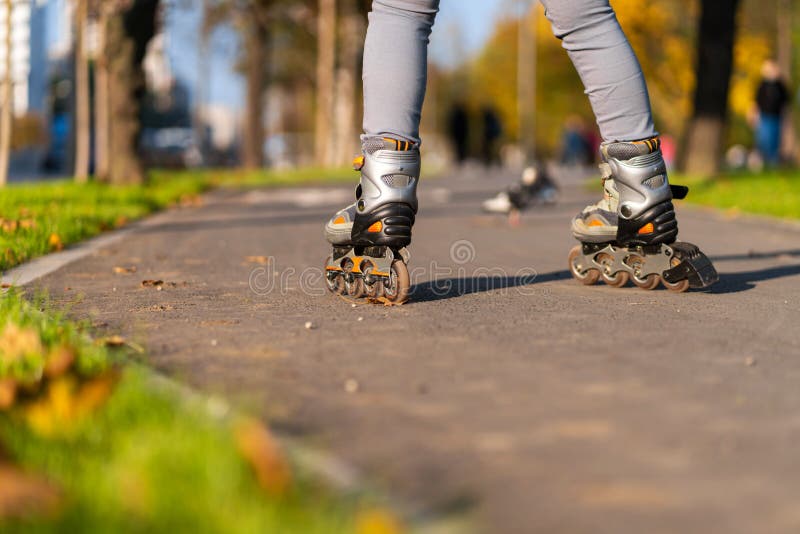 Active Leisure. a Sportive Girl is Rollerblading in an Autumn Park ...