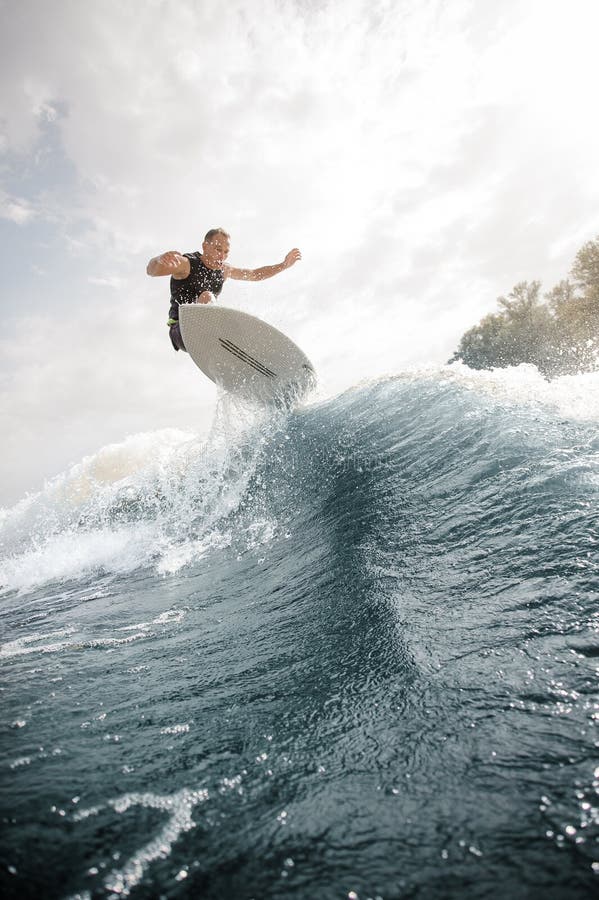 Professional Wakeboarder Jumping on the Blue Splashing Wave Against the ...