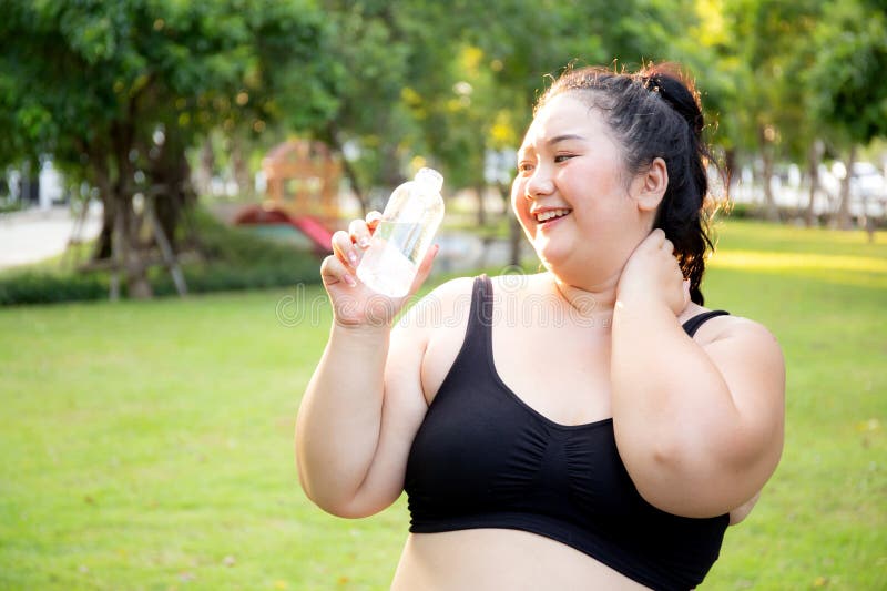 Active Plus Size Woman Hydration Drinking a Water Bottle Outdoors ...