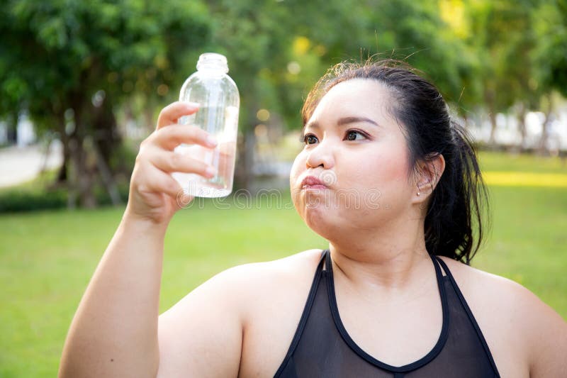 Active Plus Size Woman Hydration Drinking a Water Bottle Outdoors ...
