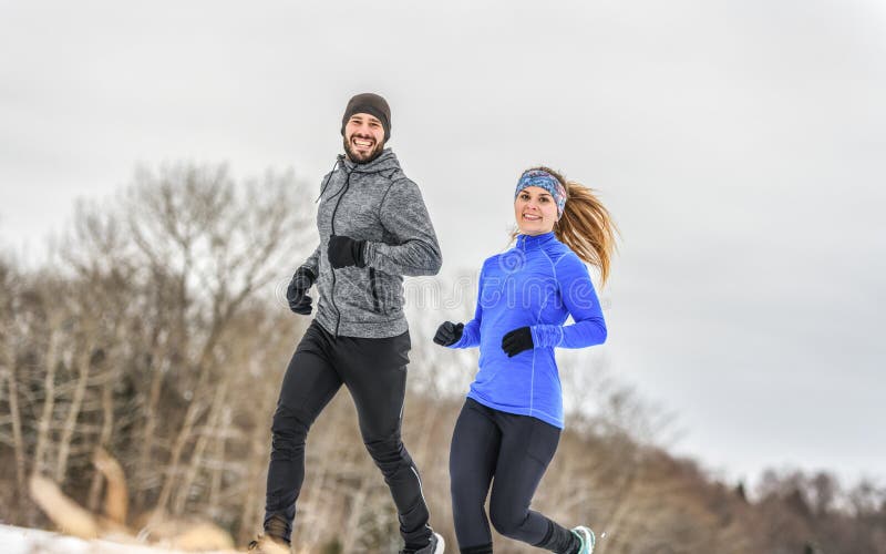 Active Runner Couple Jogging Together in Snowy Path in Nature. Stock ...