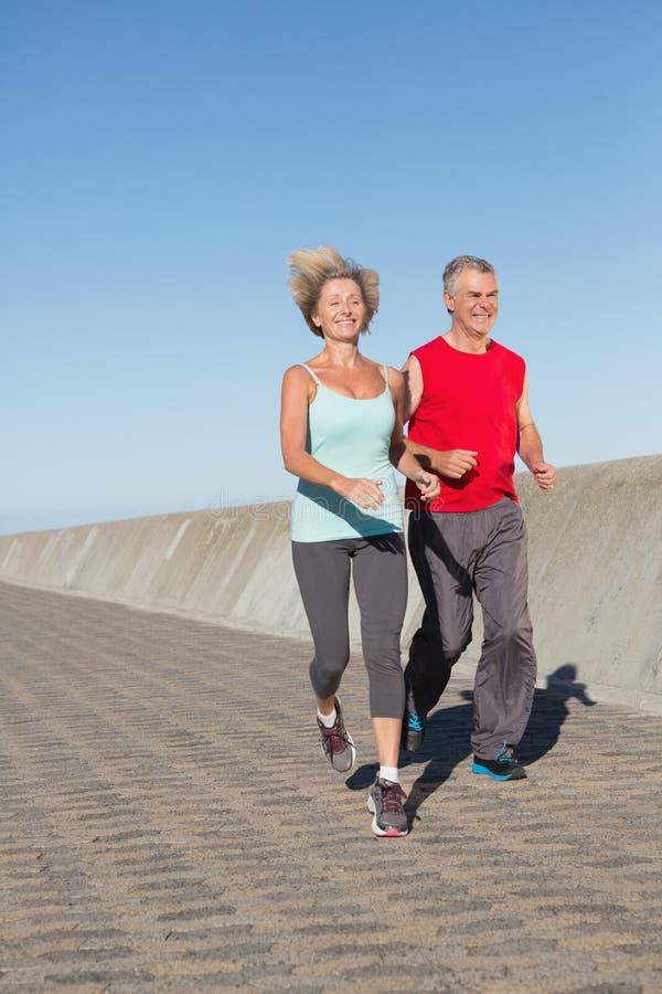 Two Healthy Senior People Jogging on a Country Road in Summer Stock ...