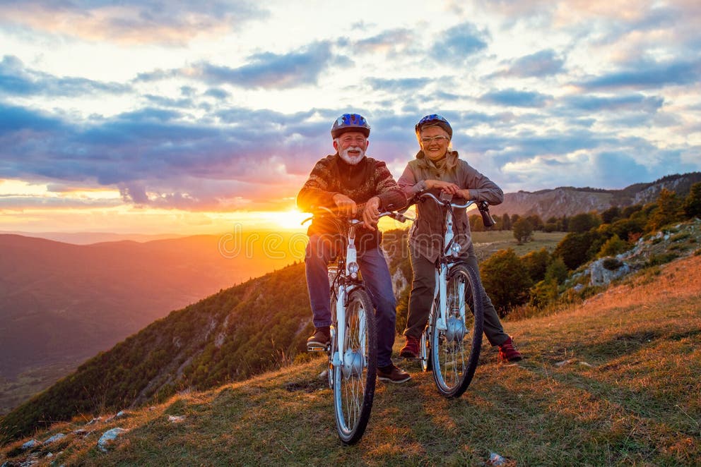 Active Senior Couple Riding Bikes in Park Stock Image - Image of ...