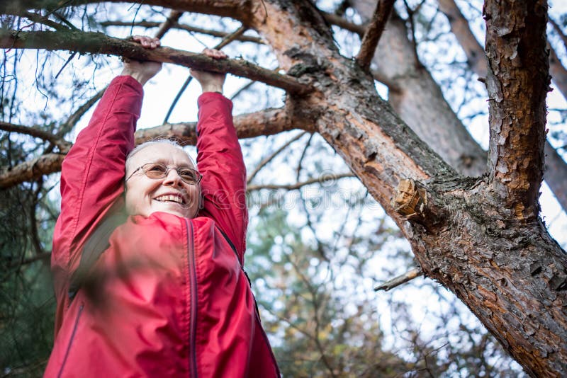 Active Senior Woman Happy Hanging from Tree in Forest Stock Photo ...