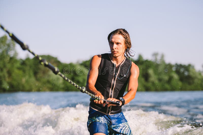 Active Wakesurfer Jumping on Wake Board Down the River Waves. Surfer on ...