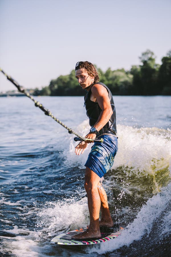 Active Wakesurfer Jumping on Wake Board Down the River Waves. Surfer on ...