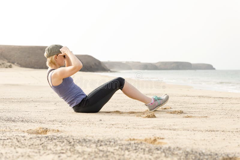 Active Woman Doing Sit-Ups by the Beach Stock Image - Image of athletic ...