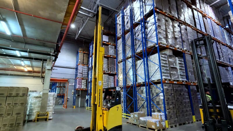 Active Work in the Warehouse. Modern Forklift Works in a Warehouse ...