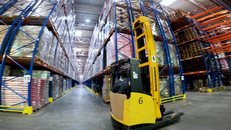 Active Work in the Warehouse. Modern Forklift Works in a Warehouse ...