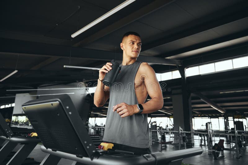 Active Young Guy in Grey Tshirt Drinking Water from Bottle, Standing on ...
