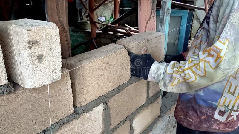 A Builder Installing, Stacking and Tidying Bricks Using a Waterpass ...