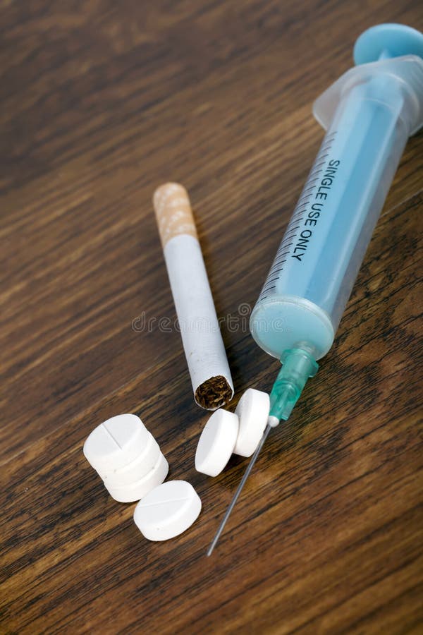 Addiction Concept with a Syringe, Cigarette and Pills Stock Photo ...