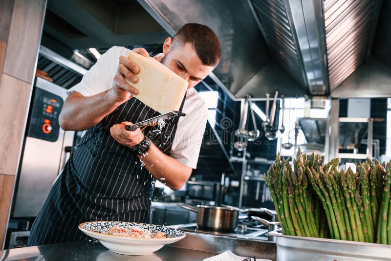 Adding Cheese. Chef is on the Kitchen Preparing Food Stock Image ...
