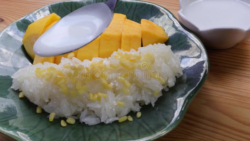 Adding Coconut Milk on Delectable Sticky Rice with Fresh Ripe Mango ...