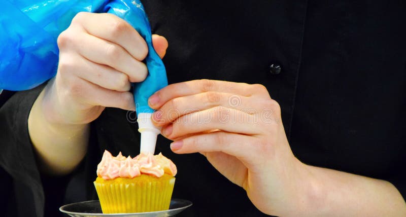 Adding Frosting To a Cupcake Stock Photo - Image of baker, cafe: 135866350