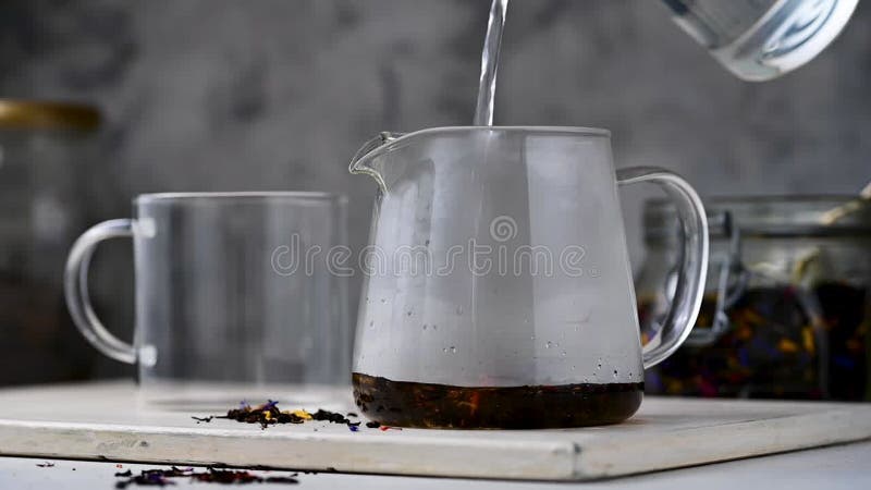 Adding Hot Water To Glass, Tea Pot with Loose Black Leaf Tea. Making ...