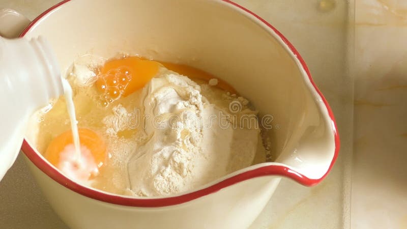Adding Milk To Eggs and Flour To Make a Batter Mix in a Jug Stock ...