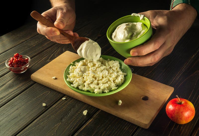 Adding Milk Yogurt To Cheese with a Spoon in the Cook S Hand. Preparing ...