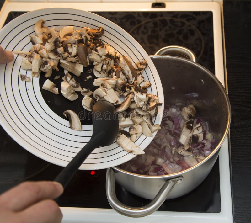 Adding mushrooms stock photo. Image of hand, stove, mushrooms - 68063418