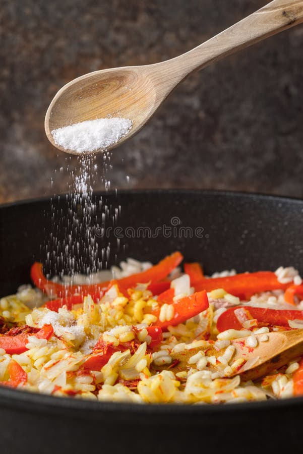 Adding Salt in the Pan with Rice and Bell Pepper Vertical Stock Photo ...