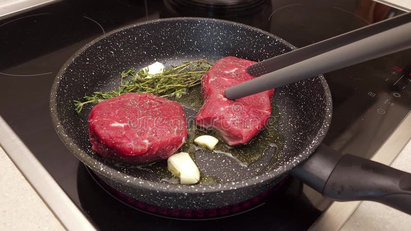 Adding Garlic and Thyme To Beefsteak into Frying Pan Stock Video ...