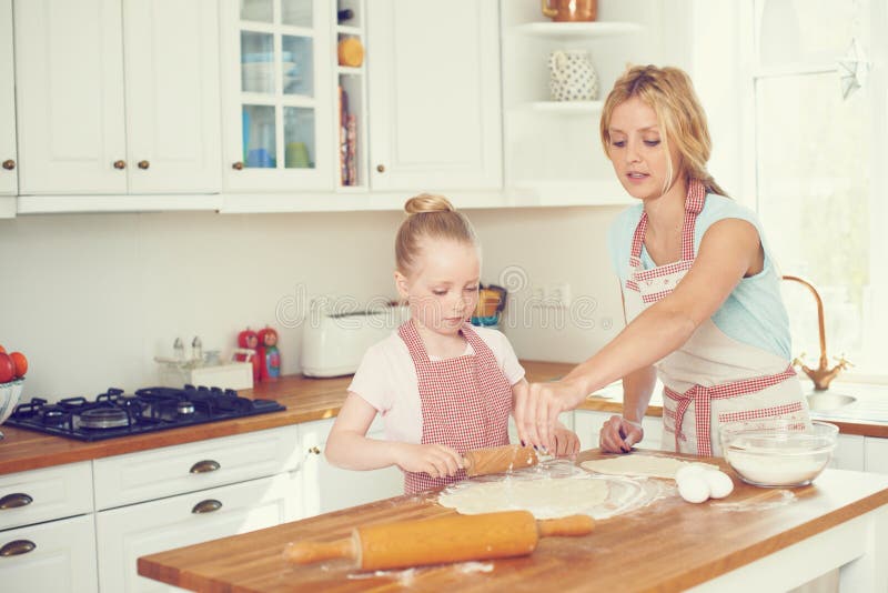Adding a Sprinkle of Flour. Cute Little Girl Baking in the Kitchen with ...
