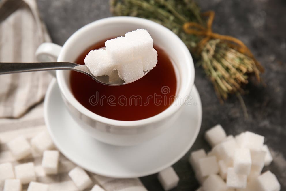 Adding of Sugar To Cup with Aromatic Tea on Grey Table Stock Image ...