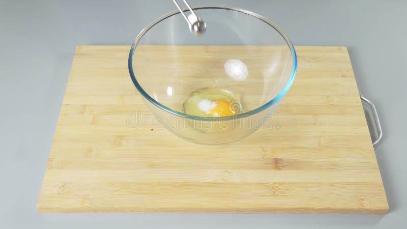 Adding a Tablespoon of Salt To Raw Eggs in Bowl before Beating Them ...