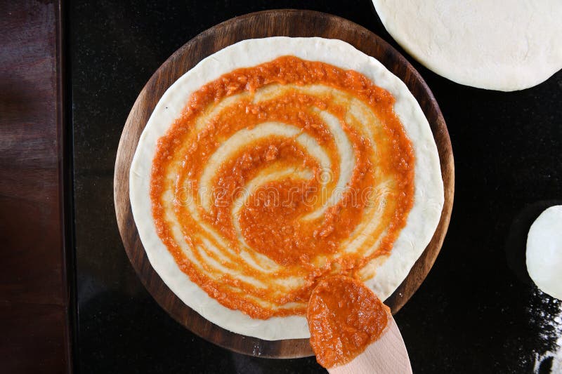 Adding Tomato Sauce To Pizza Base Stock Photo - Image of close ...