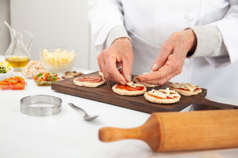 Adding Toppings To the Mini Pizzas. Adding Cheese Stock Photo - Image ...