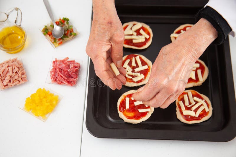 Adding Toppings To the Mini Pizzas. Adding Cheese Stock Image - Image ...