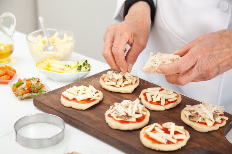 Adding Toppings To the Mini Pizzas. Adding Chicken Stock Photo - Image ...