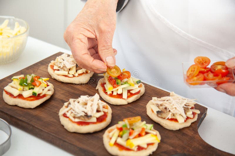 Adding Toppings To the Mini Pizzas. Delicious Homemade Mini Pizzas ...