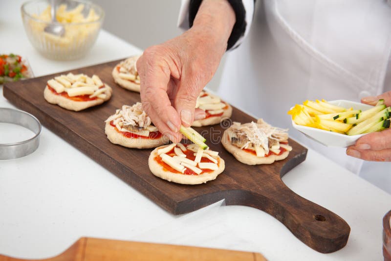 Adding Toppings To the Mini Pizzas. Adding Vegetables Stock Image ...