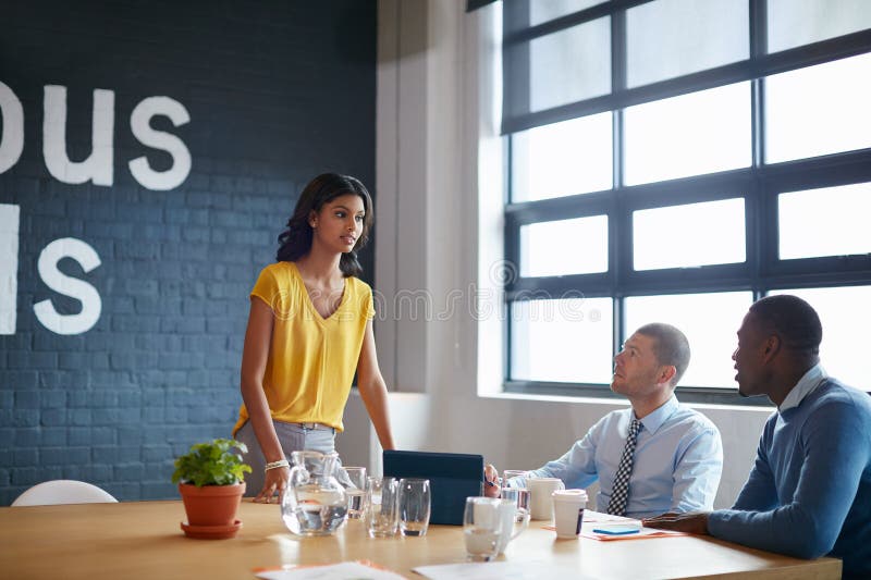 Addressing Her Colleagues. Three Businesspeople in the Office. Stock ...