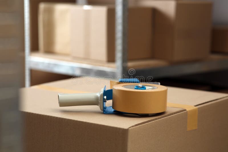 Adhesive Tape Dispenser on Cardboard Box Indoors Stock Photo - Image of ...