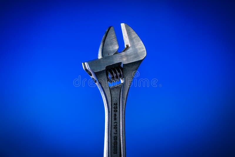 Adjustable wrench on blue stock image. Image of close - 130594533
