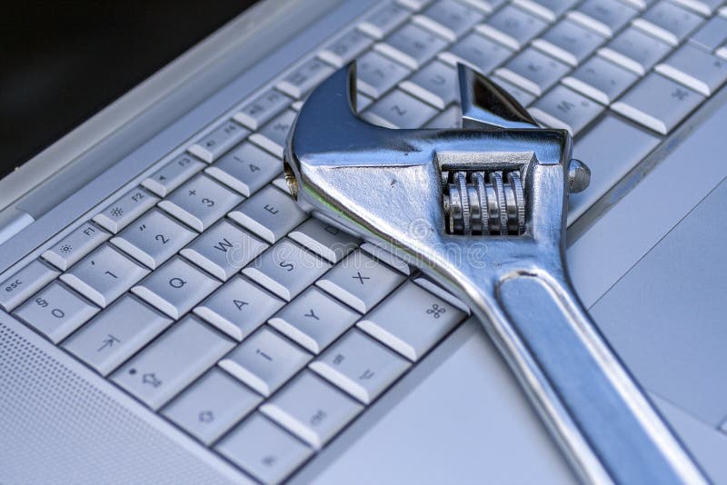 Adjustable Wrench Next To a Silver Laptop. Computer Service ...