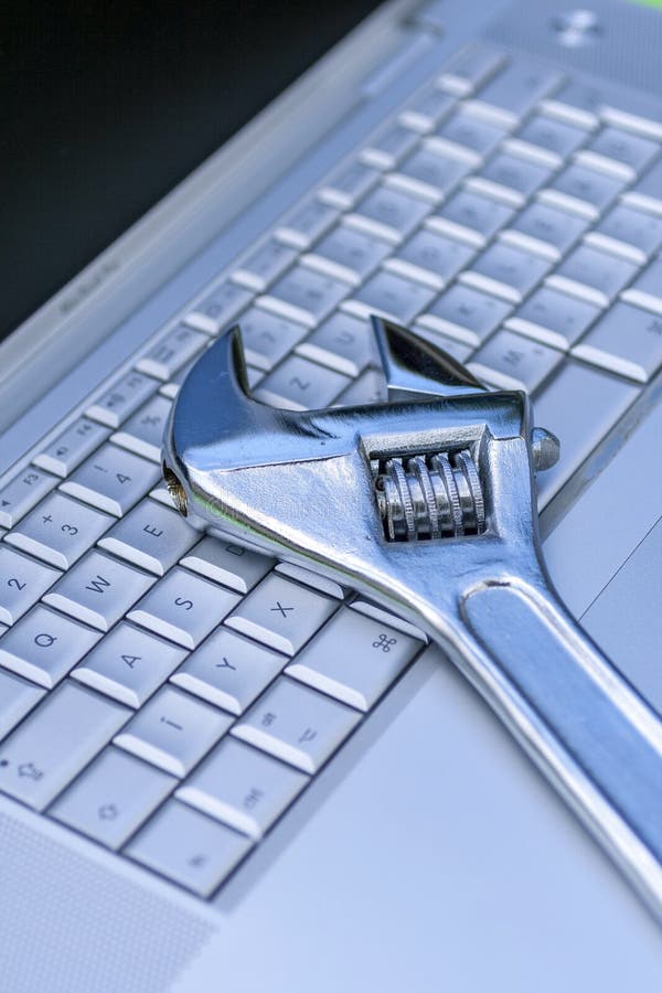 Adjustable Wrench Next To a Silver Laptop. Computer Service ...