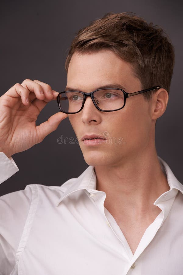 Adjusting His Spectacles Closeup Of A Handsome Young Man Touching The