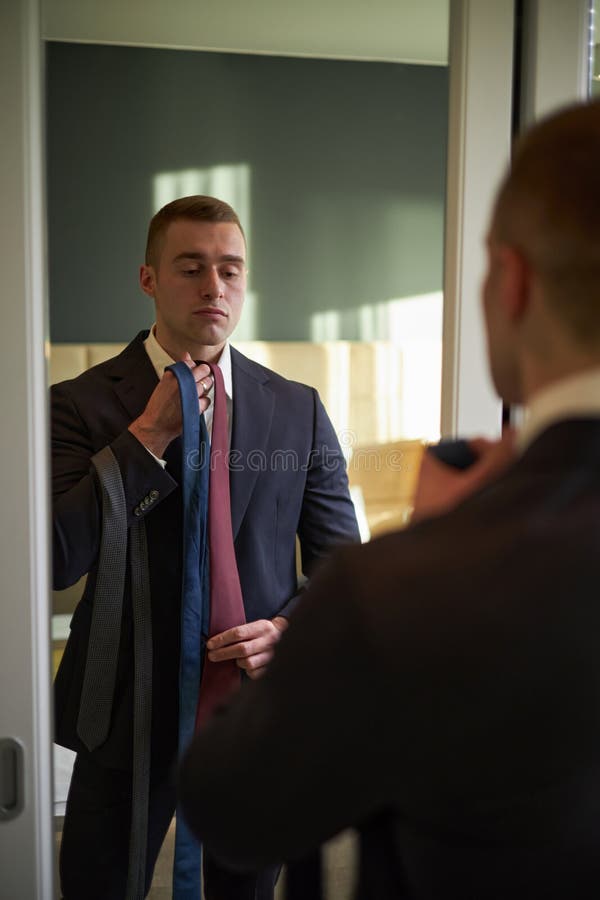 Adjusting Neck Tie in Front of Mirror in Office Setting Stock Image - Image of work, preparation ...