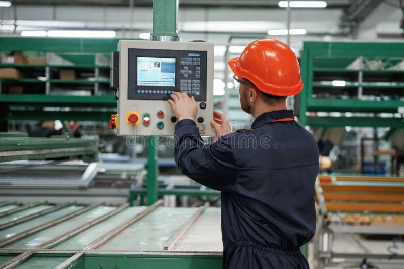 Adjusting Settings of Machine, Operating. Factory Worker is Indoors ...