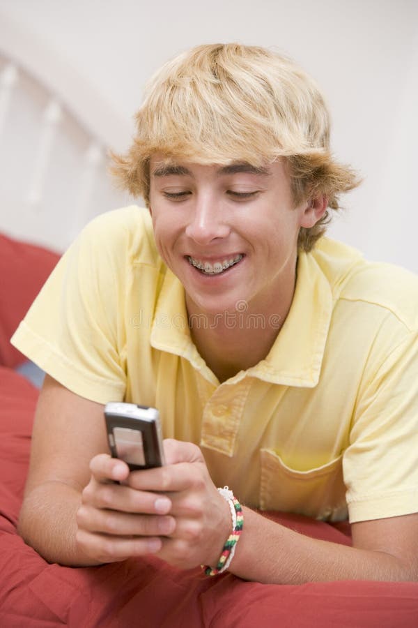 Adolescente Que Miente En Cama Usando El Teléfono Móvil Imagen De