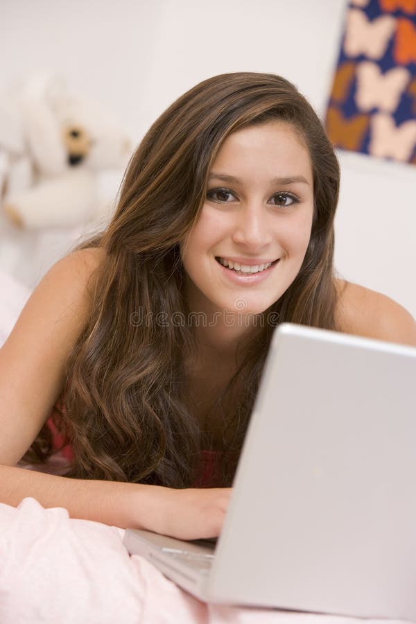 Adolescente Que Miente En Su Cama Usando La Computadora Portátil Imagen