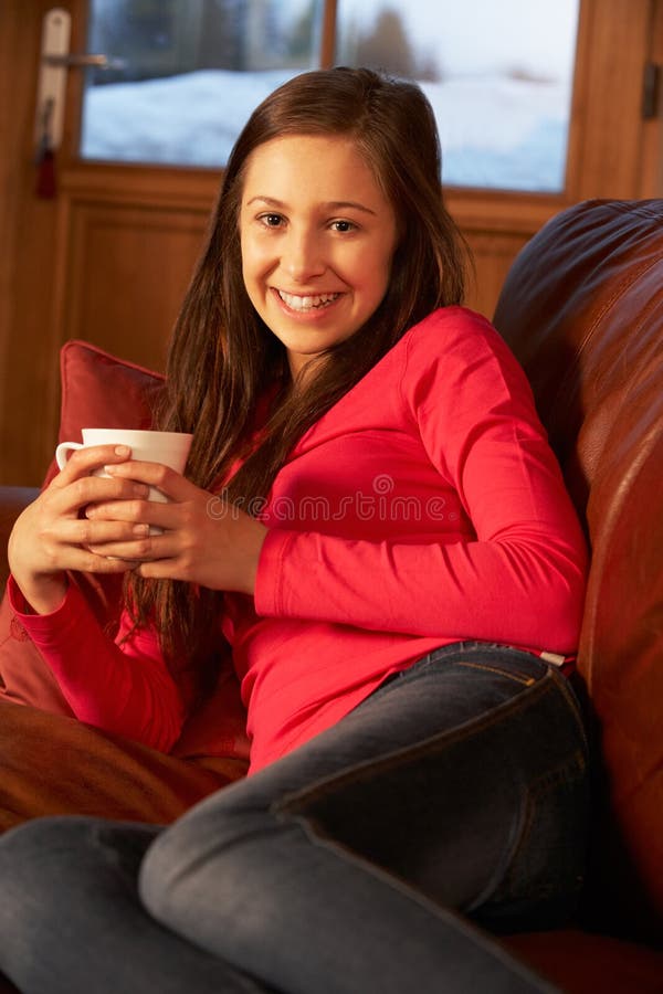 Adolescente Que Se Relaja En El Sofá Con La Bebida Caliente Foto de ...
