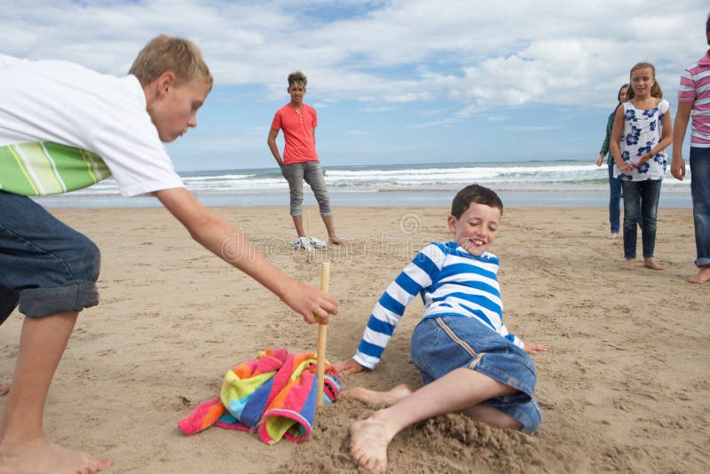 Adolescentes Que Juegan Al Grillo En La Playa Foto De Archivo Imagen