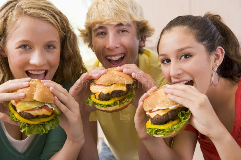 Adolescenti Che Mangiano Gli Hamburger Immagine Stock - Immagine di ...