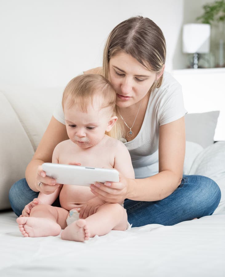 Adorable Baby in Diapers Using Tablet PC with His Mother Stock Photo ...
