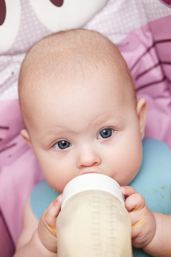 Baby 6 Months Old Sits and Drinks Milk from a Bottle Stock Image ...